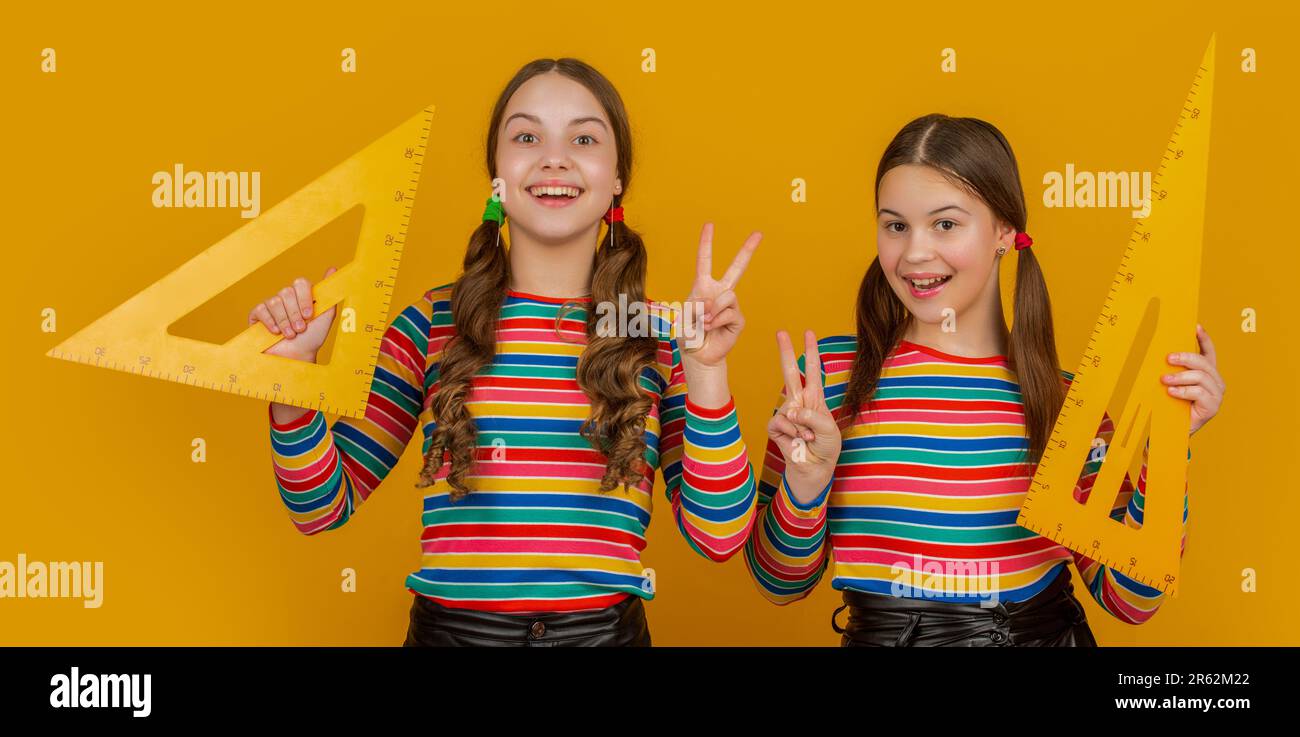 smiling school children hold math tool of triangle Stock Photo - Alamy