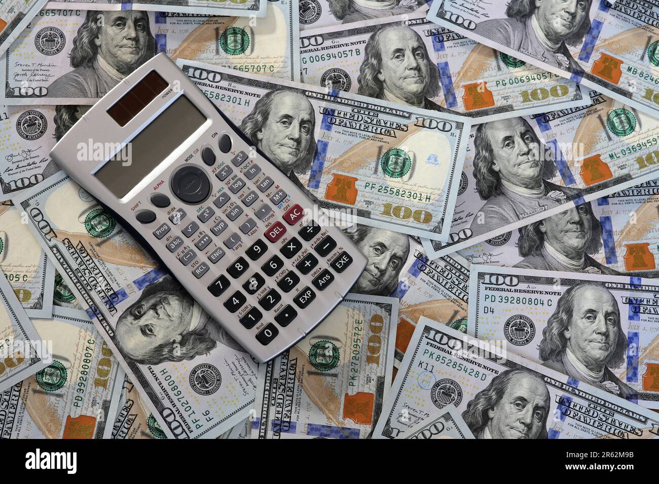 A calculator with a background of 100 US Dollar bills Stock Photo - Alamy