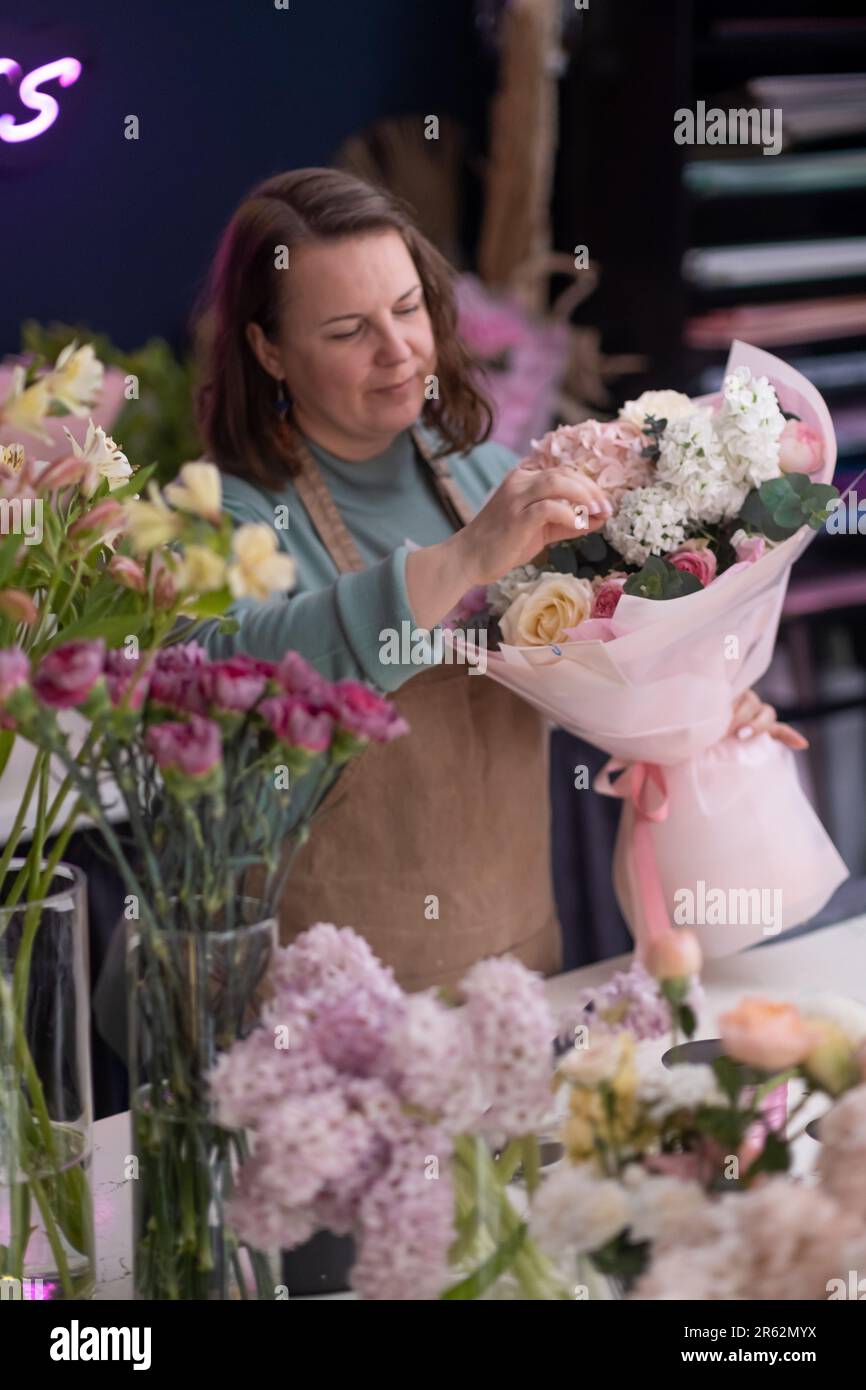 A skilled female florist expertly crafting a unique bouquet from a ...