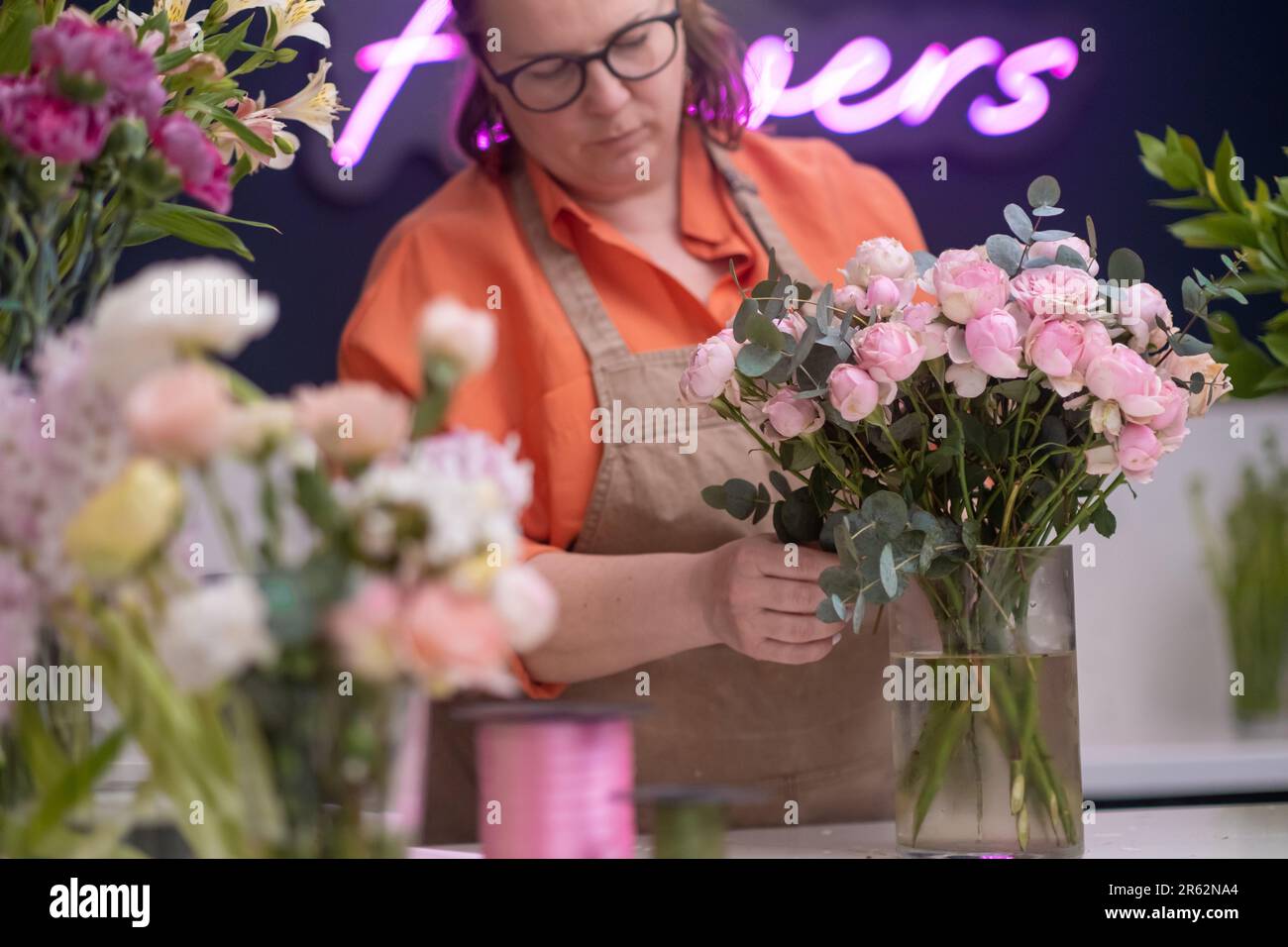 successful female business owner of flower shop mixing gorgeous bouquet ...