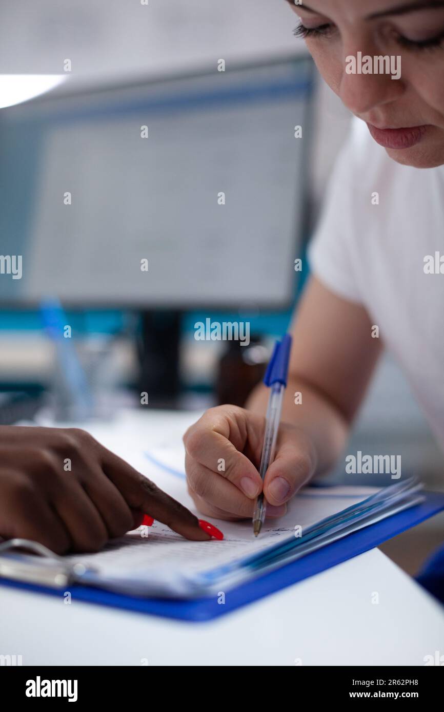 Doctor helping patient signing paperwork of medical insurance document ...