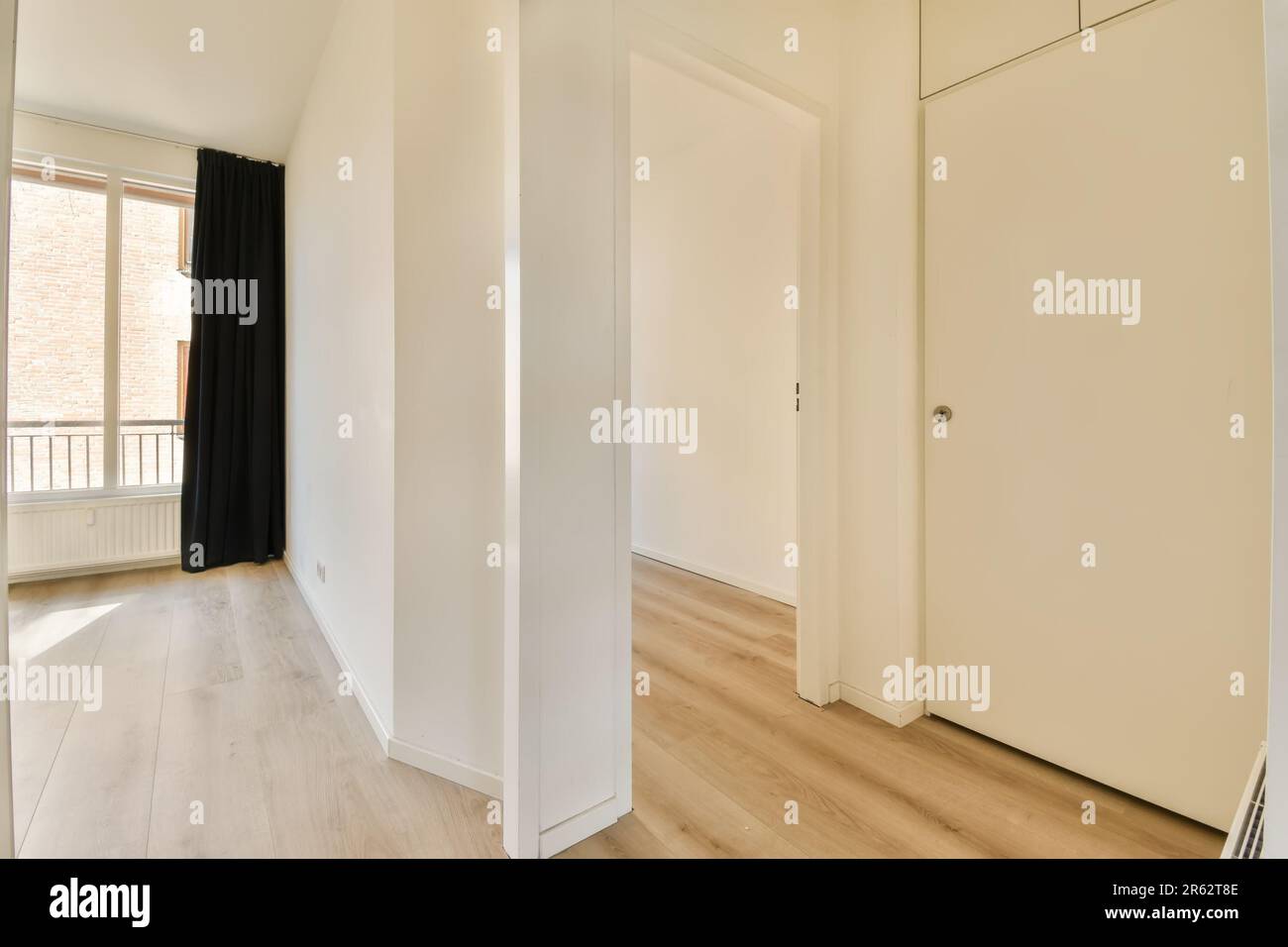 an empty room with wooden floors and white walls, there is a large ...