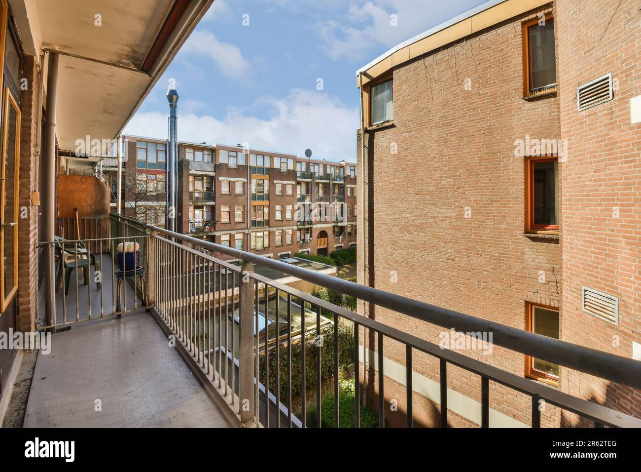 a balcony with brick walls and balks on the left side, there is a view ...