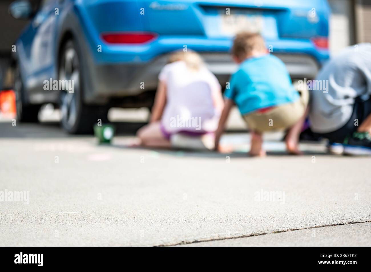 Children sitting on a driveway behind a vehicle in a blind spot out of ...