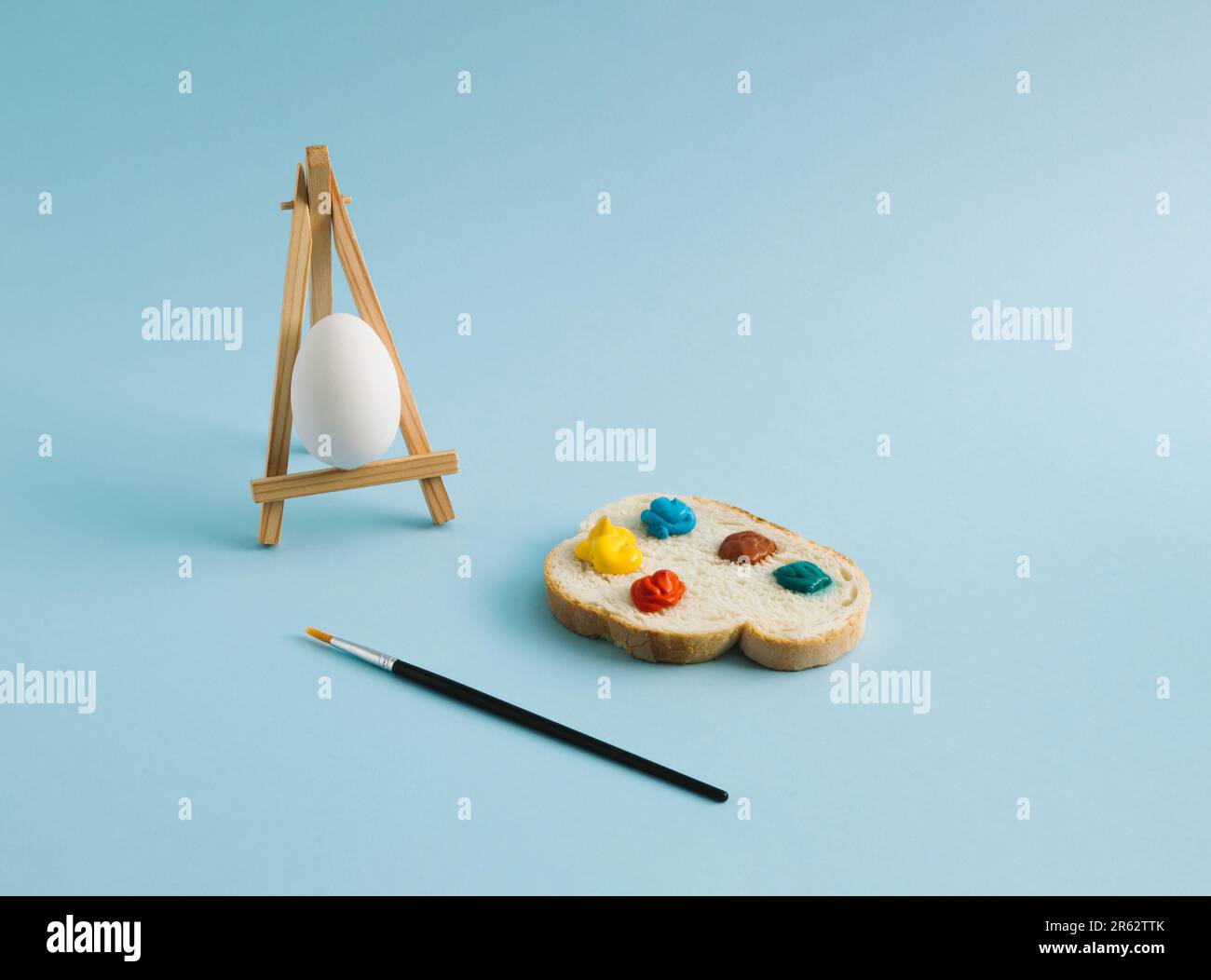 Abstract Easter composition made of white egg on easel and slice of ...