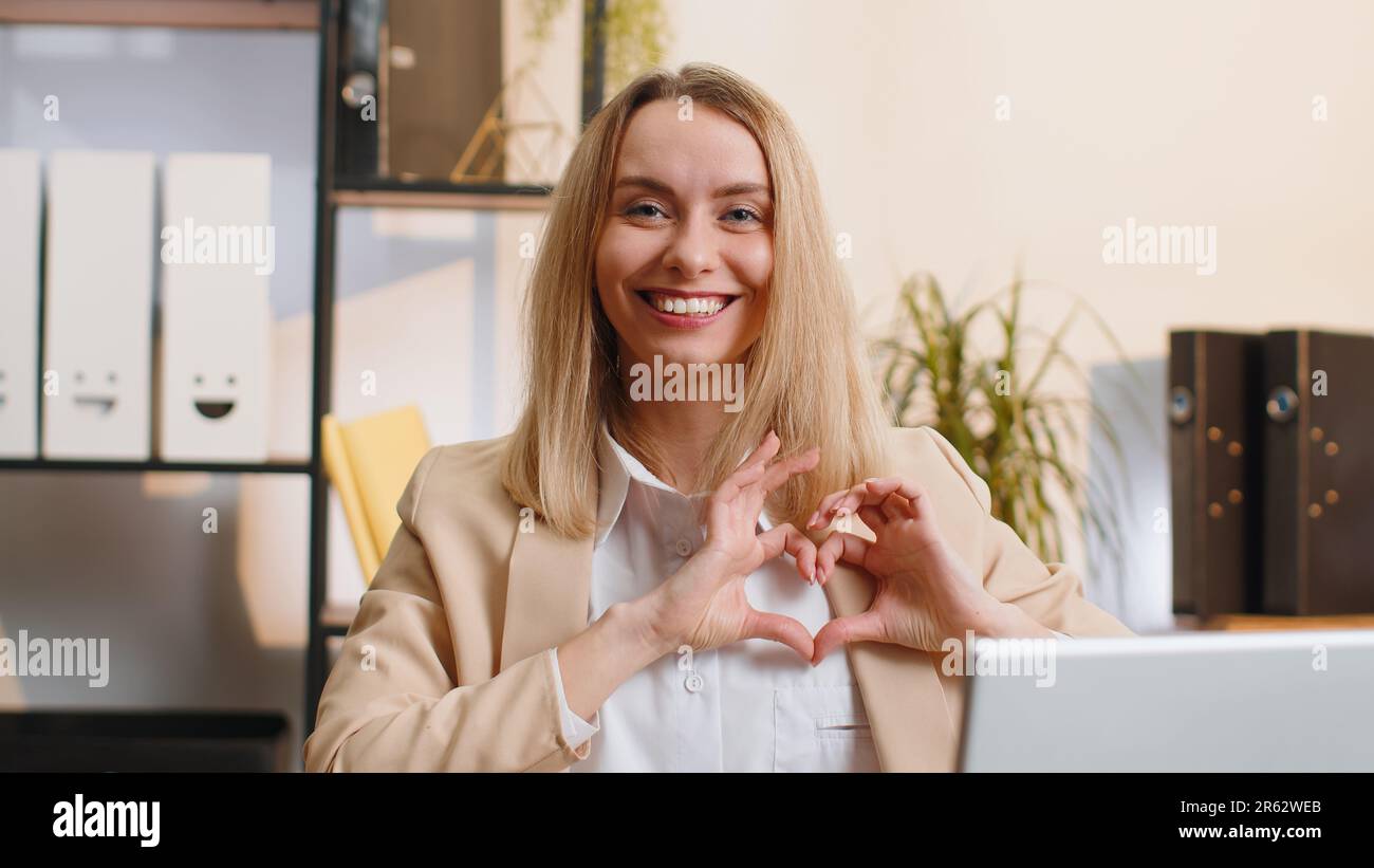 I love you. Young business woman makes symbol of love, showing heart ...