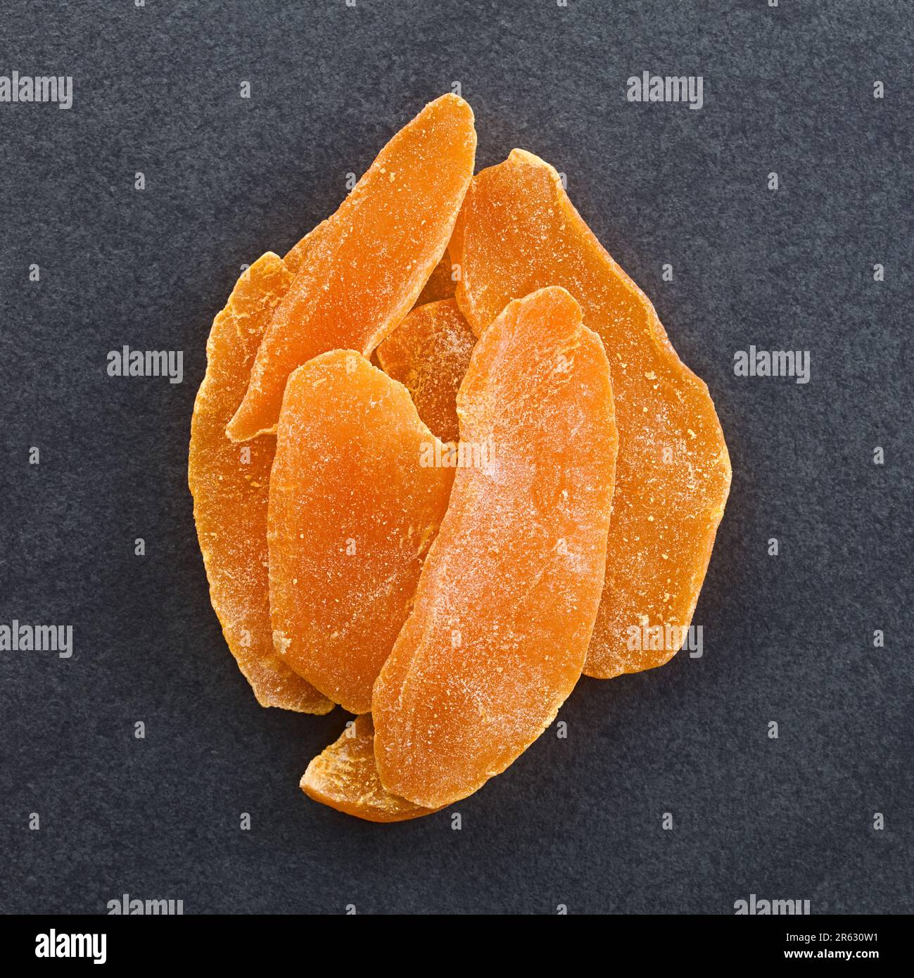 Dried candied mango fruit slices photographed overhead on slate Stock ...