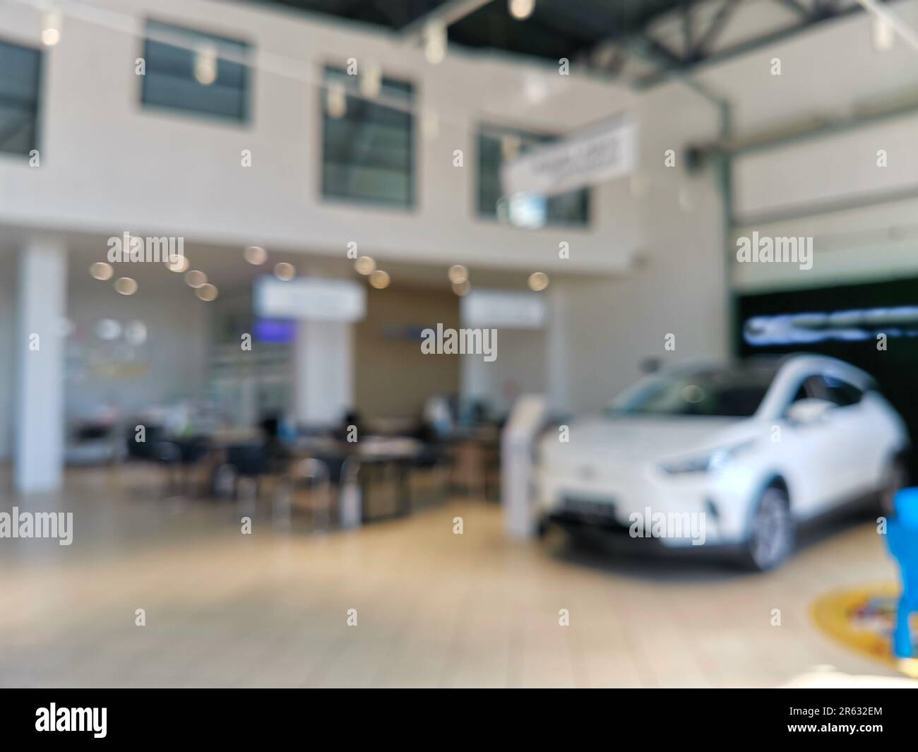 Interior of modern salon with new cars, blurred view. The sun light ...