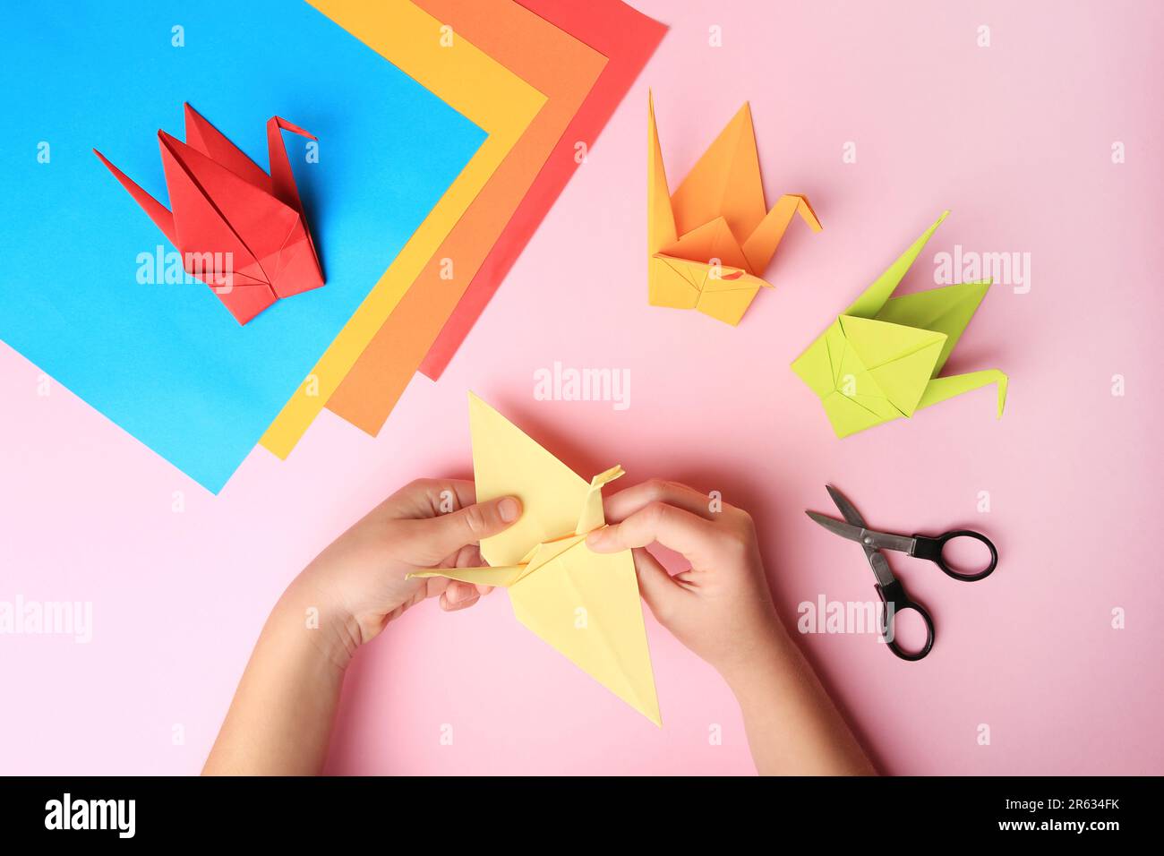 Origami art. Child holding paper figure on pink background, closeup and ...