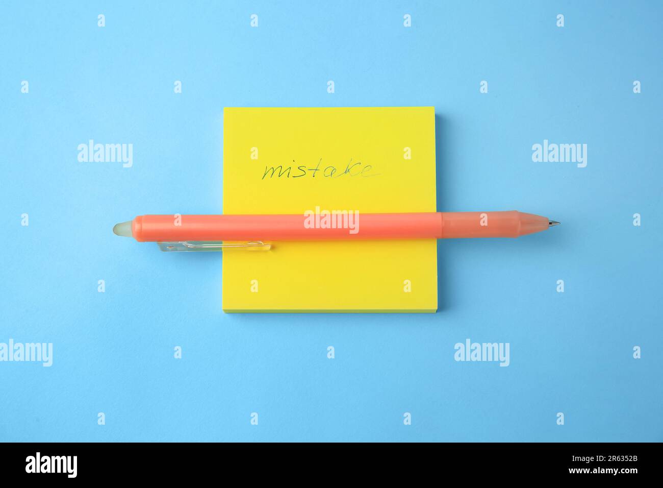 Paper notes with word Mistake and erasable pen on light blue background ...