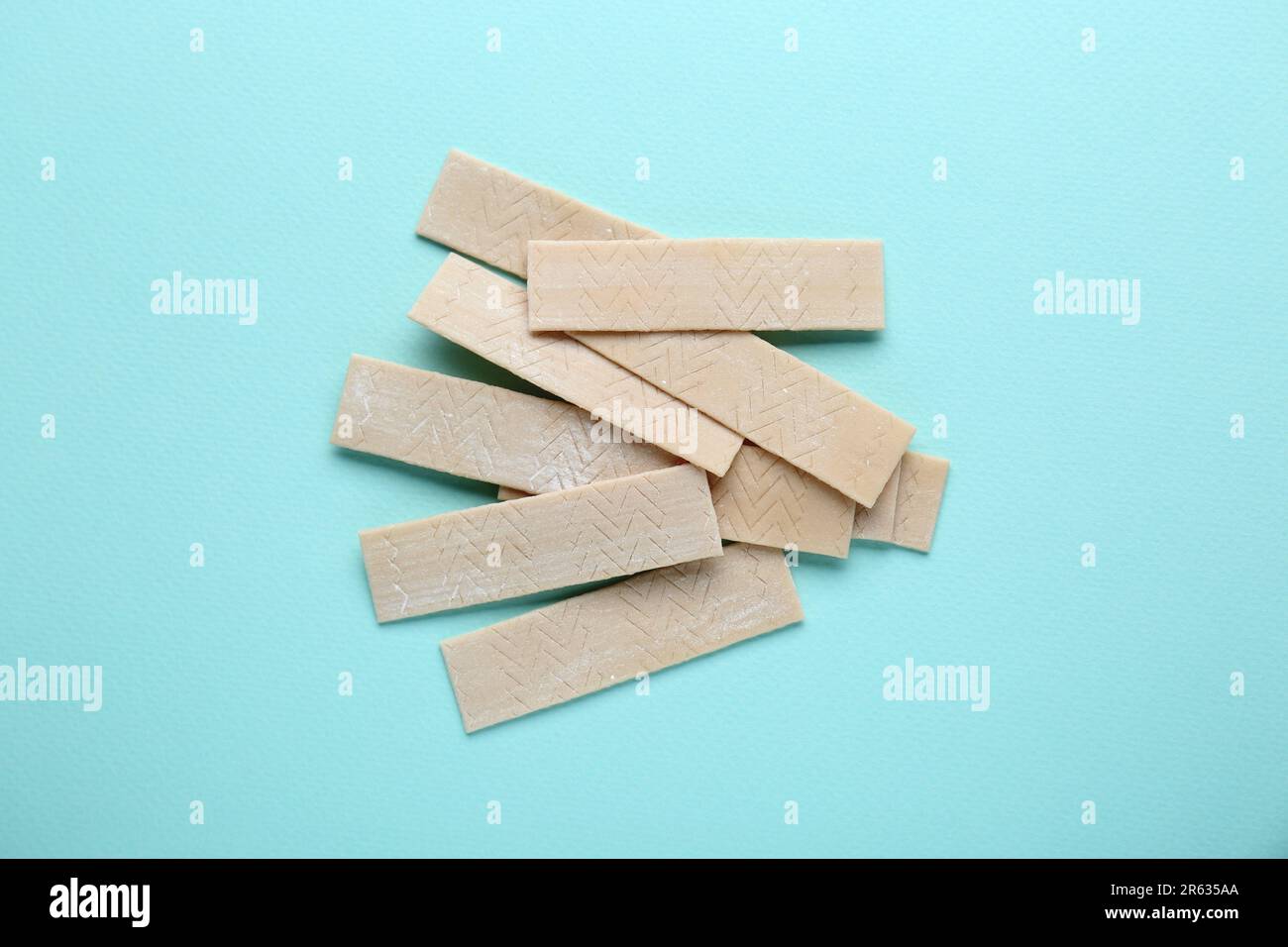 Many sticks of tasty chewing gum on light blue background, flat lay ...