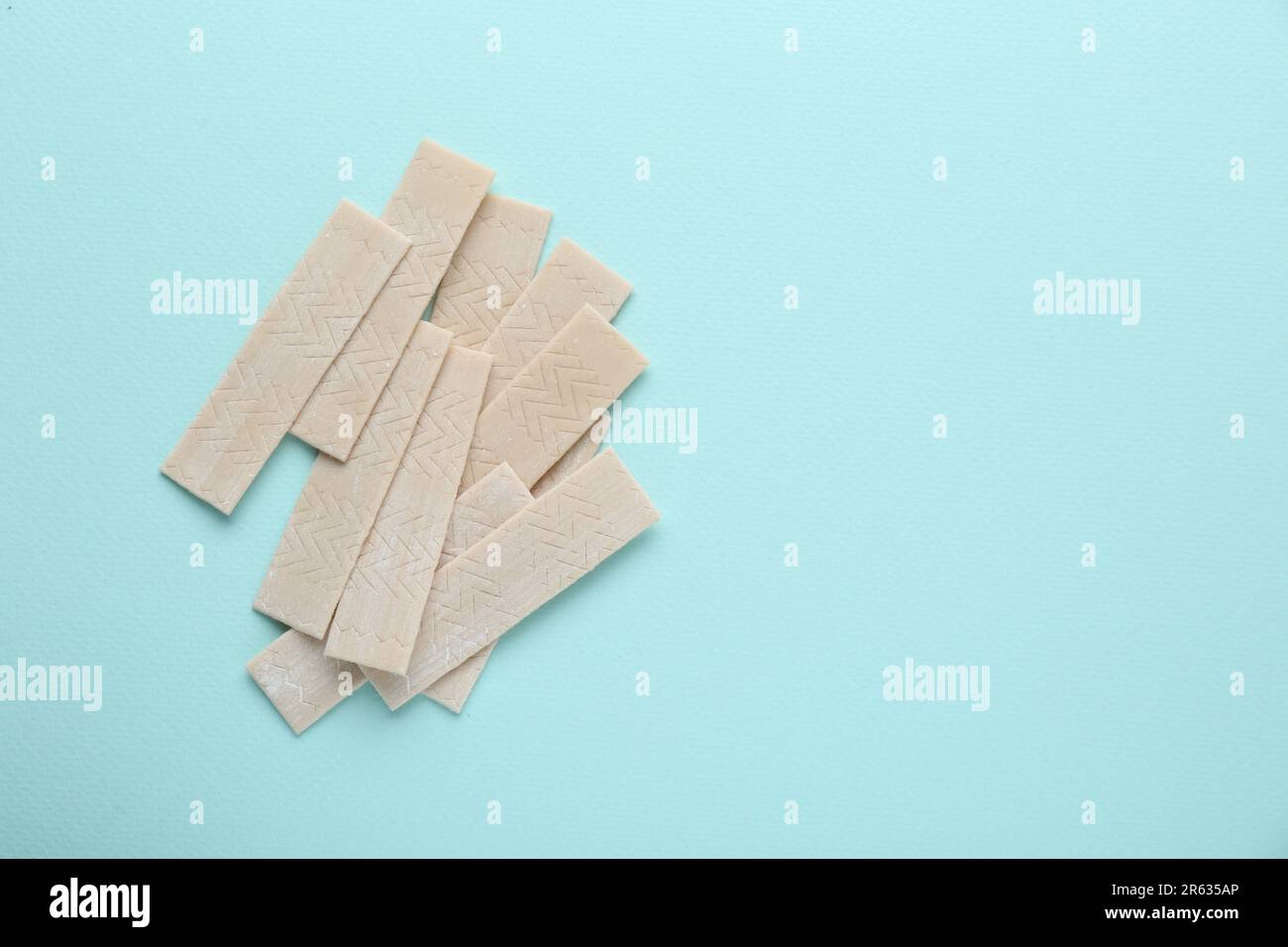 Many sticks of tasty chewing gum on light blue background, flat lay ...