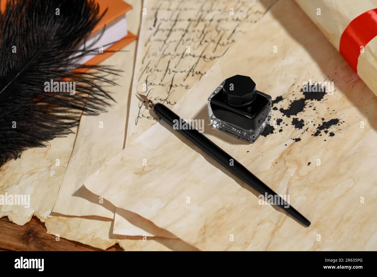 Inkwell, feather, fountain pen and vintage parchment on wooden table ...