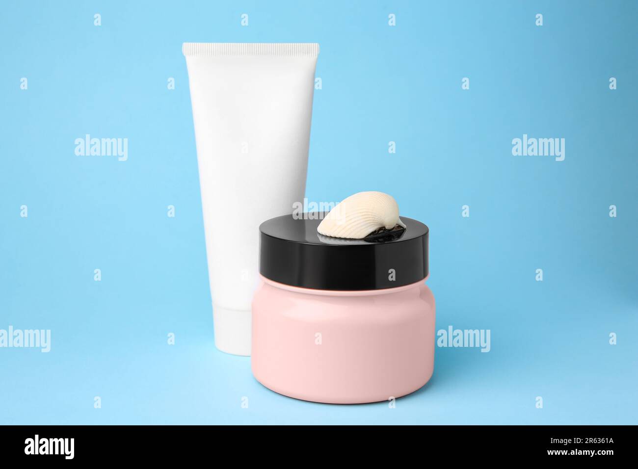 Cosmetic products and shell on light blue background Stock Photo - Alamy