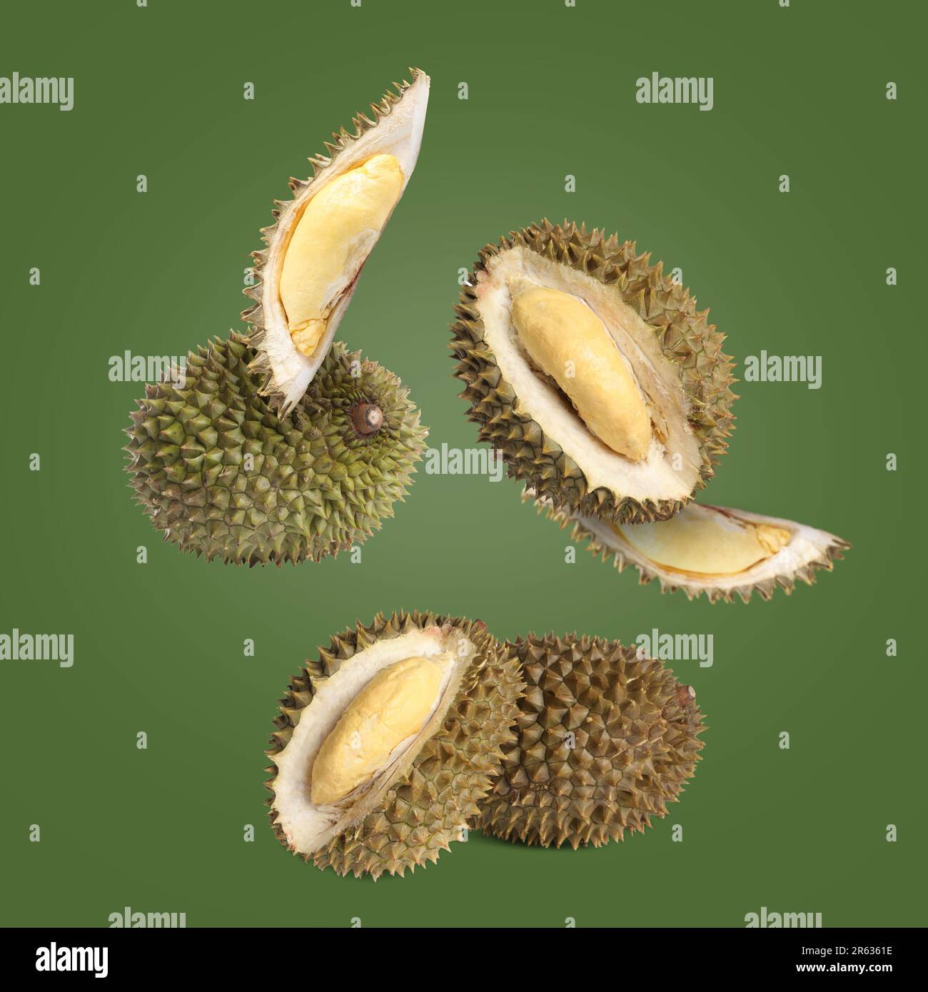 Fresh ripe durians falling on green background Stock Photo - Alamy