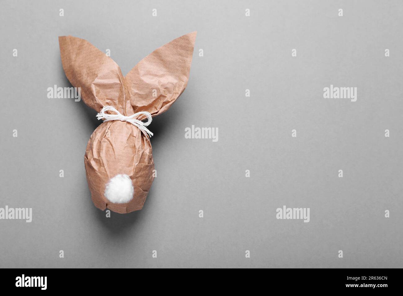Easter bunny made of kraft paper and egg on grey background, top view ...