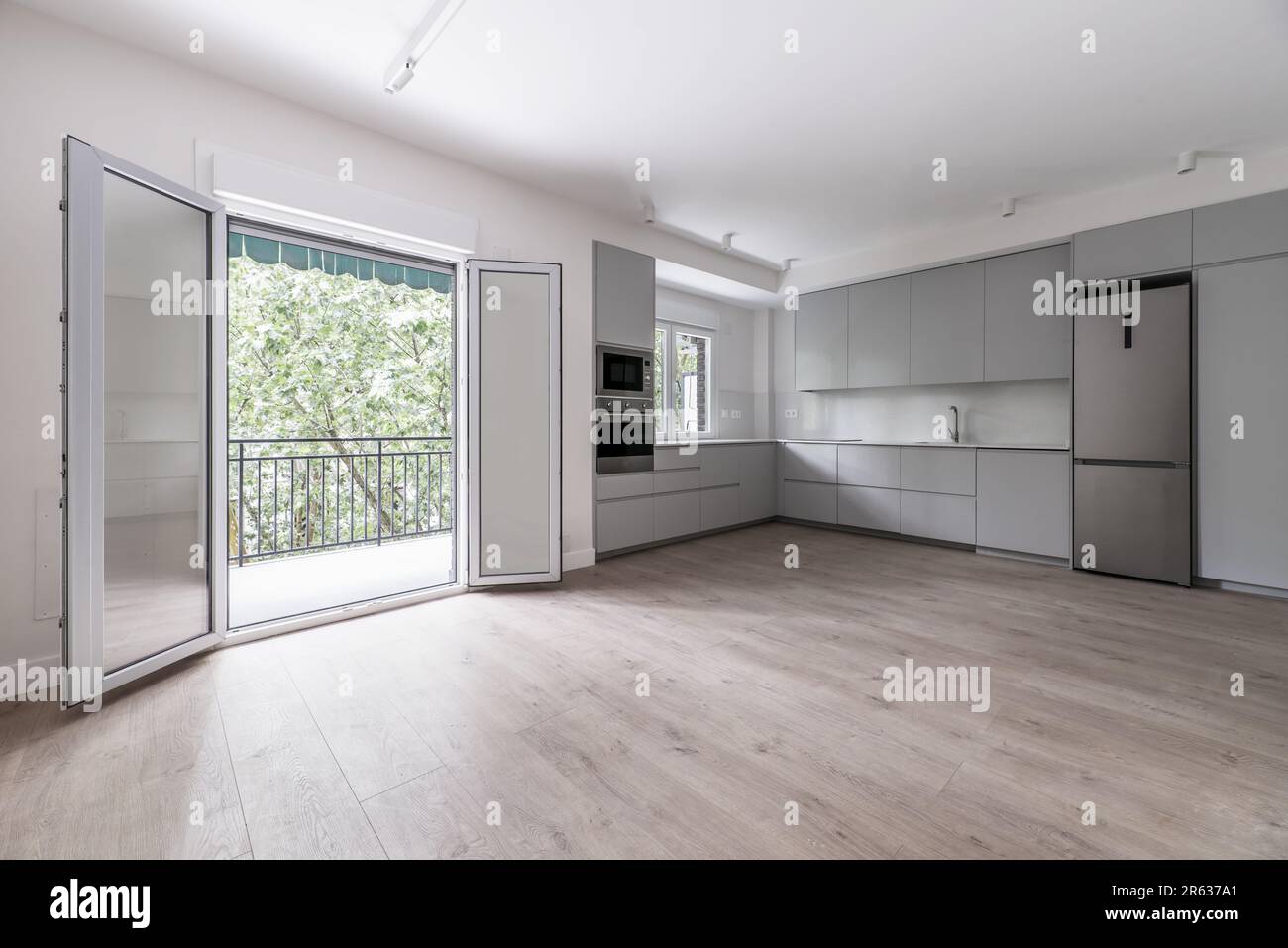 Kitchen with large empty space for living room and exit to terrace with ...