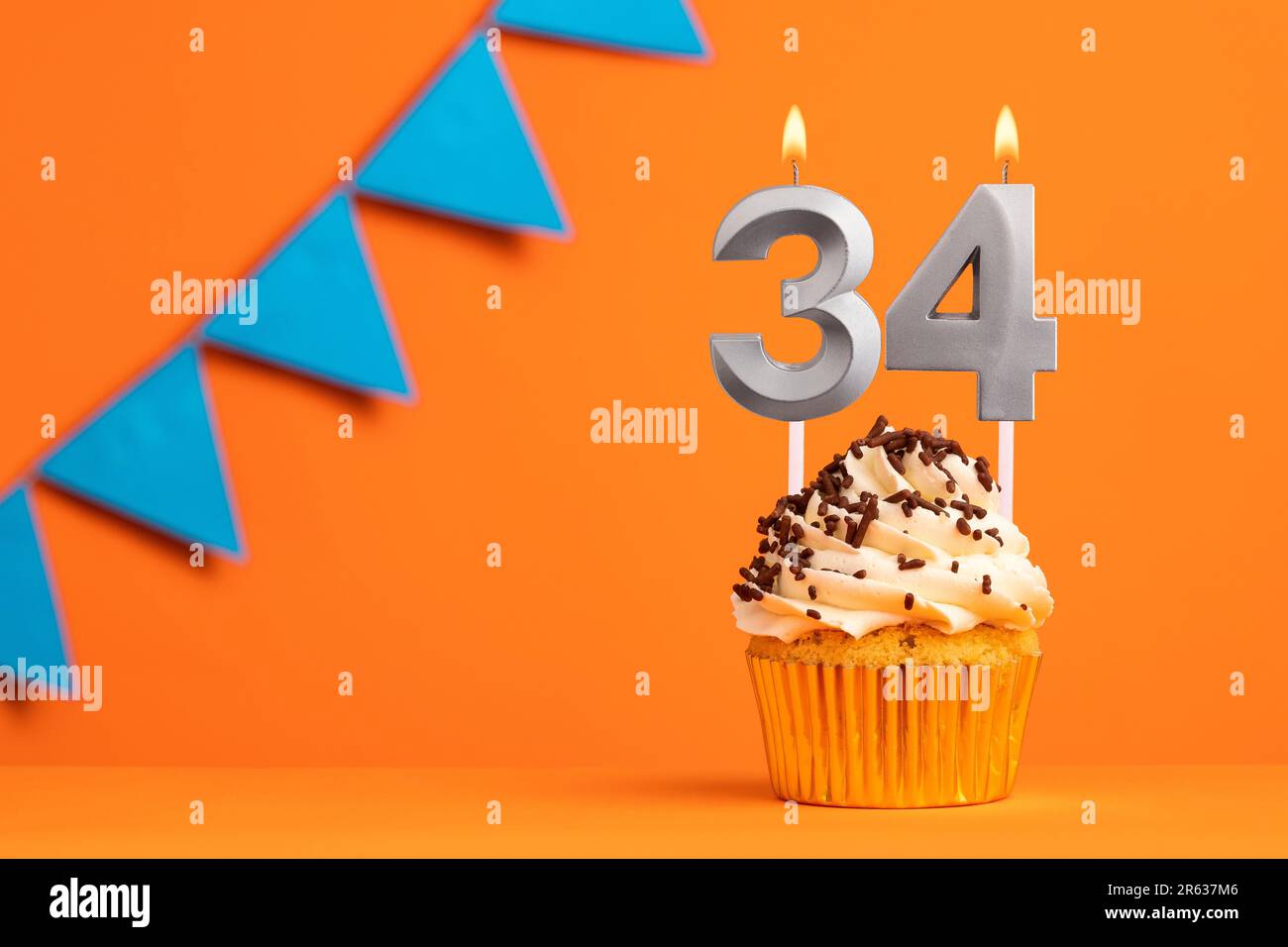 Birthday cake with candle number 34 - Orange background Stock Photo - Alamy
