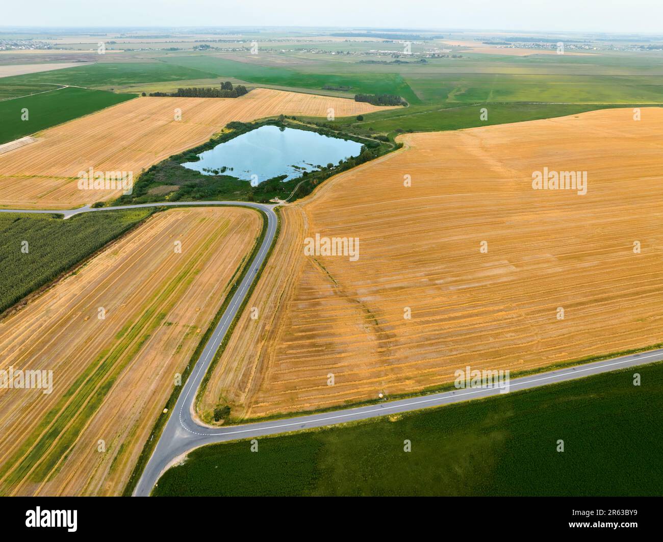 Countryside highway surrounded by green and yellow fields Stock Photo ...