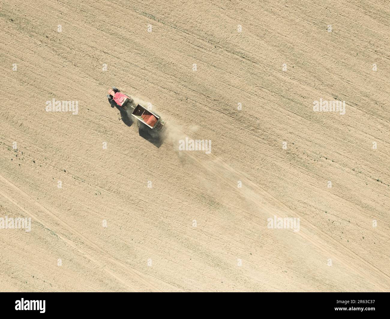 Tractor with trailer spreading fertilizer on plowed field Stock Photo ...