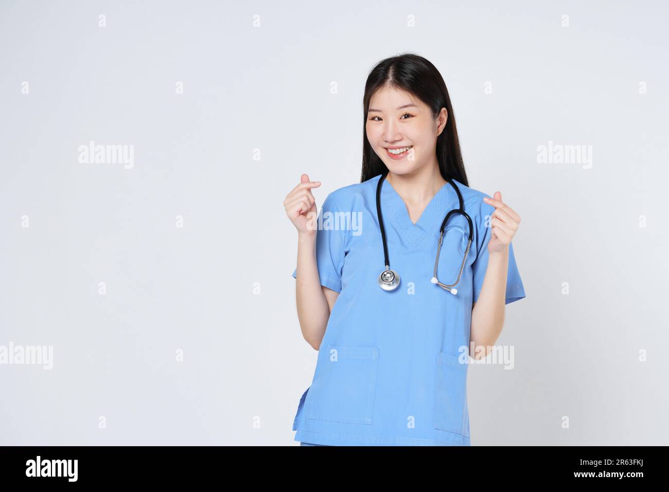 Smiling woman doctor showing mini heart sign isolated on white ...