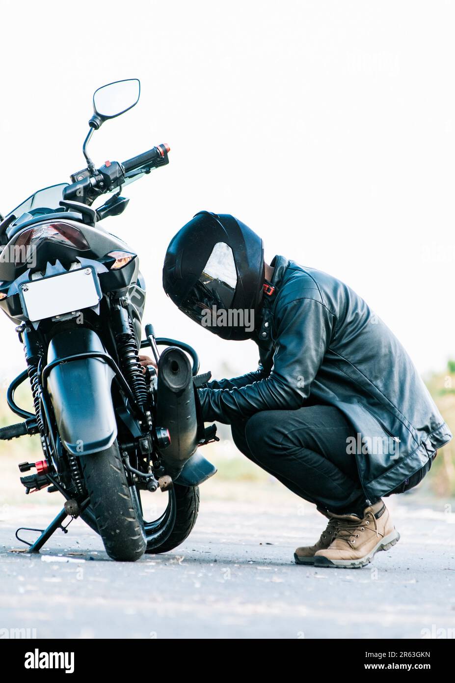 Man checking his motorcycle on the road. Motocyclist fixing the ...
