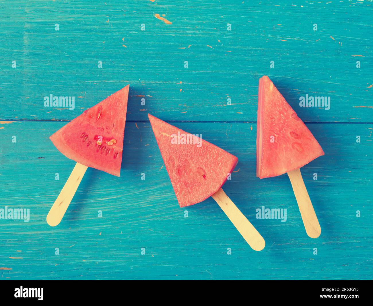 Three watermelon pops on a blue background, healthy eating of ...