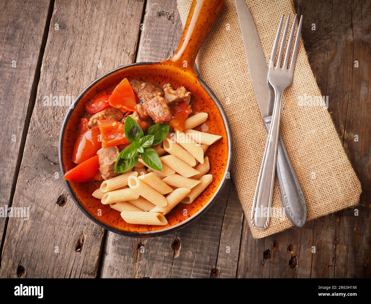 Tasty goulash with whole grain penne in a rustic pan Stock Photo - Alamy