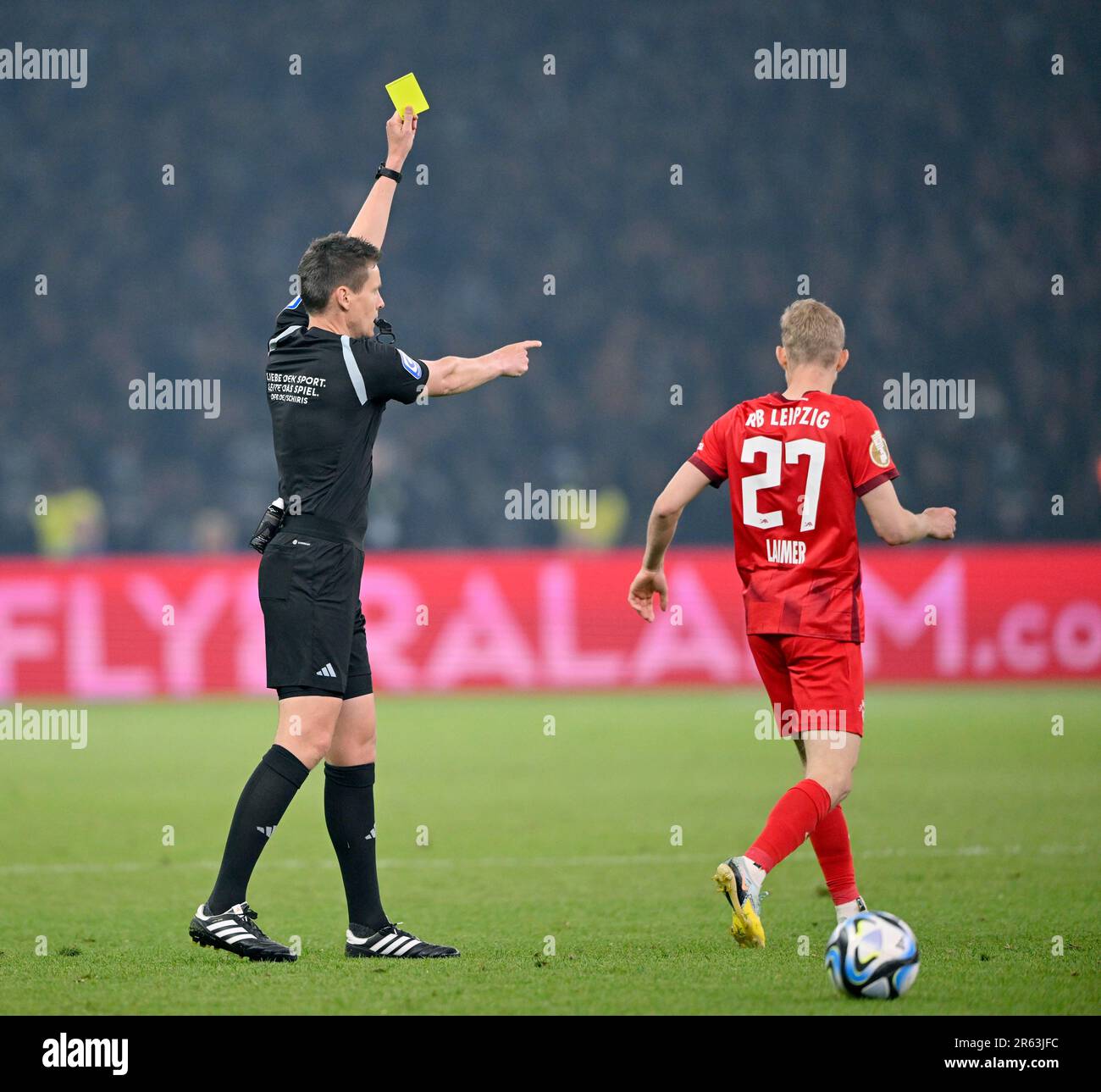 Referee Daniel Siebert shows Konrad Laimer (27) RasenBallsport Leipzig RBL yellow card, caution ...