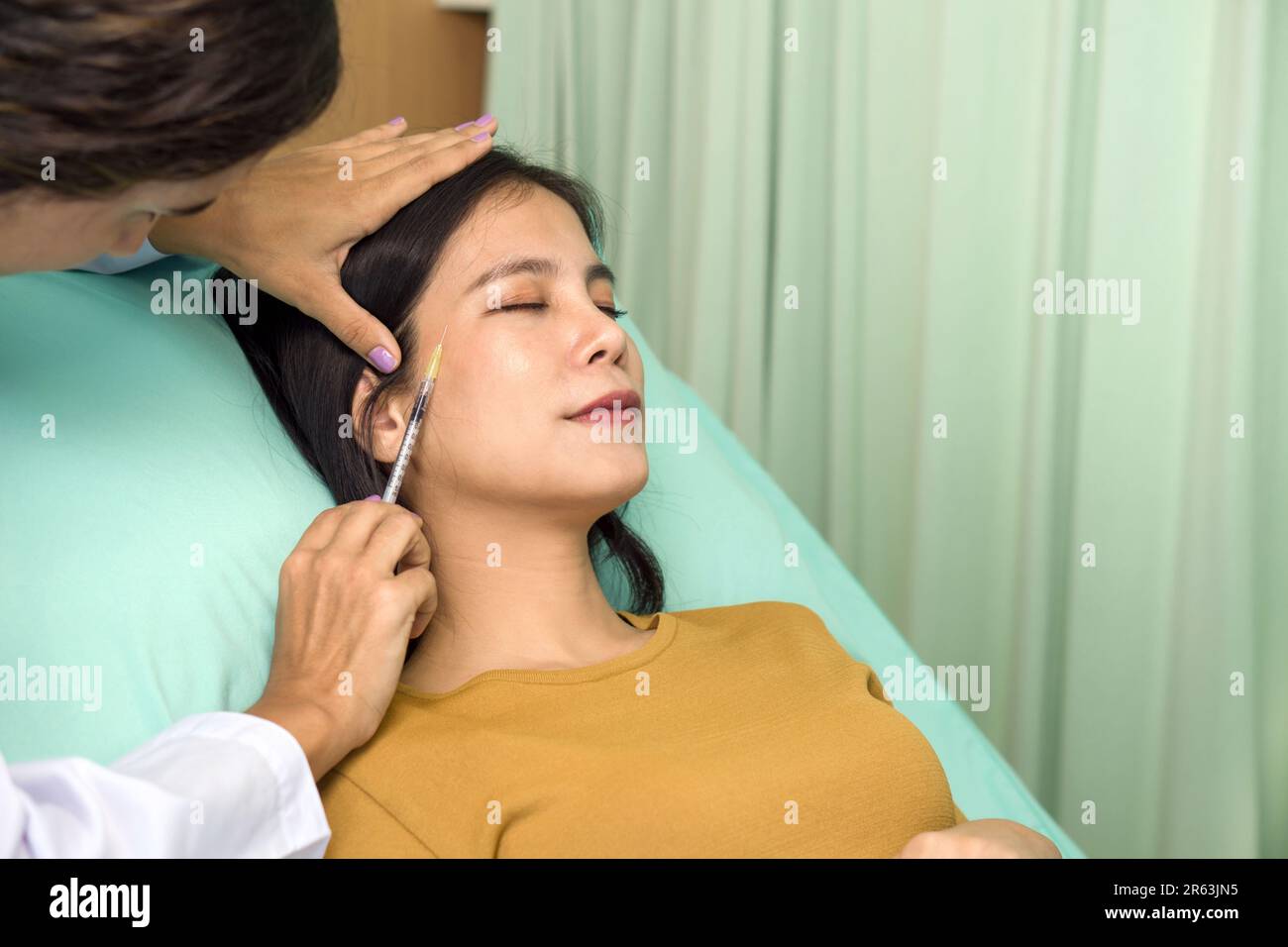 Doctor giving female patient medical injection in temporal. Atmosphere ...