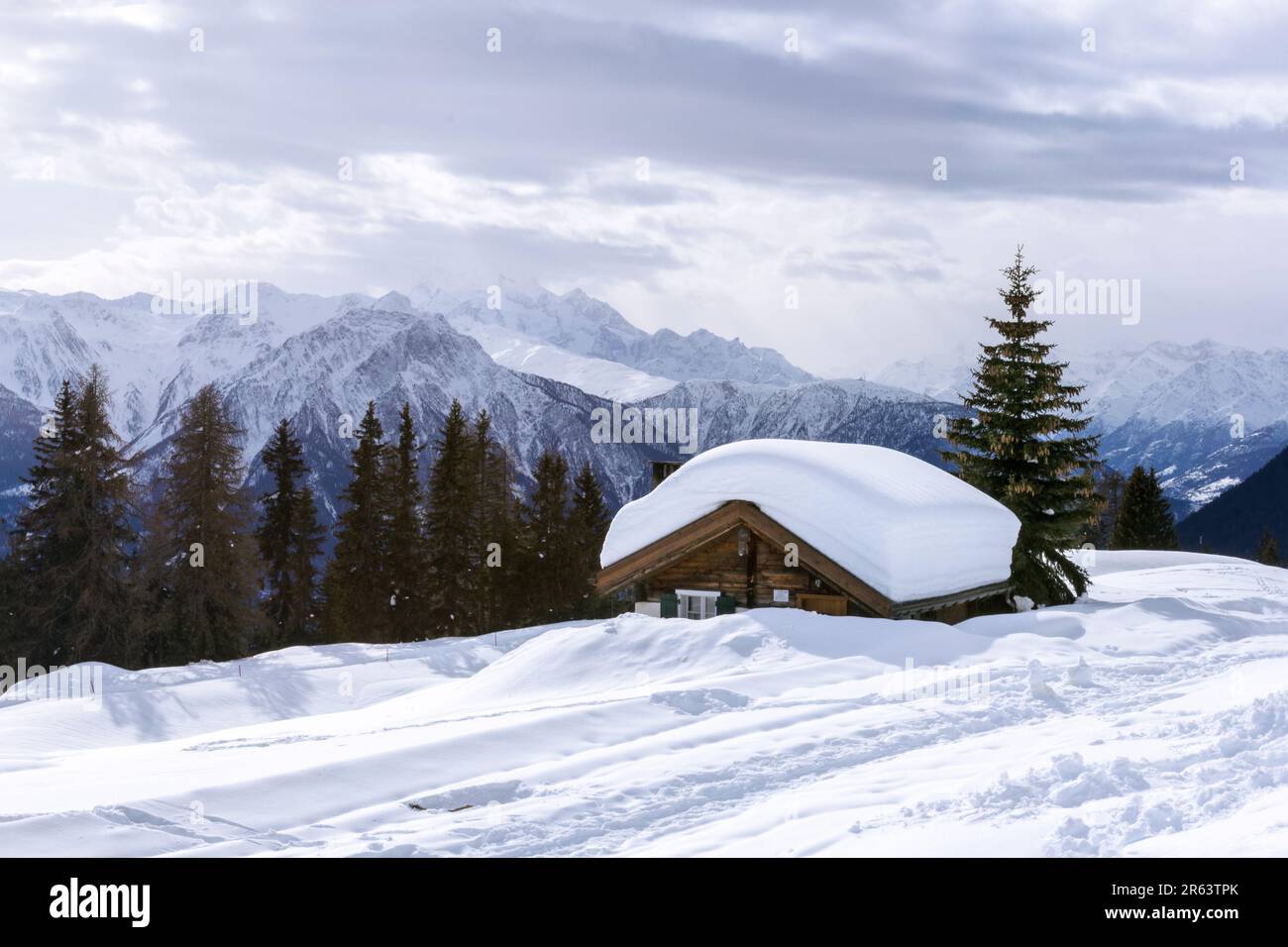 Alpine chalet sunk in deep snow in winter with thick snow on roof in ...
