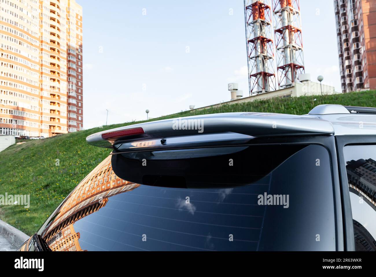 Close-up on the trunk lid of a gray car with a plastic spoiler over the ...