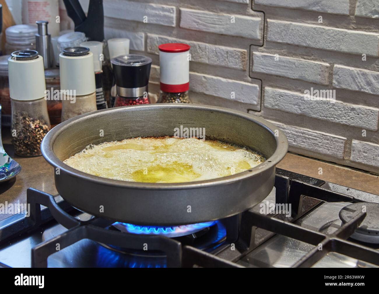 Sugar is fried in frying pan with oil on gas stove Stock Photo - Alamy
