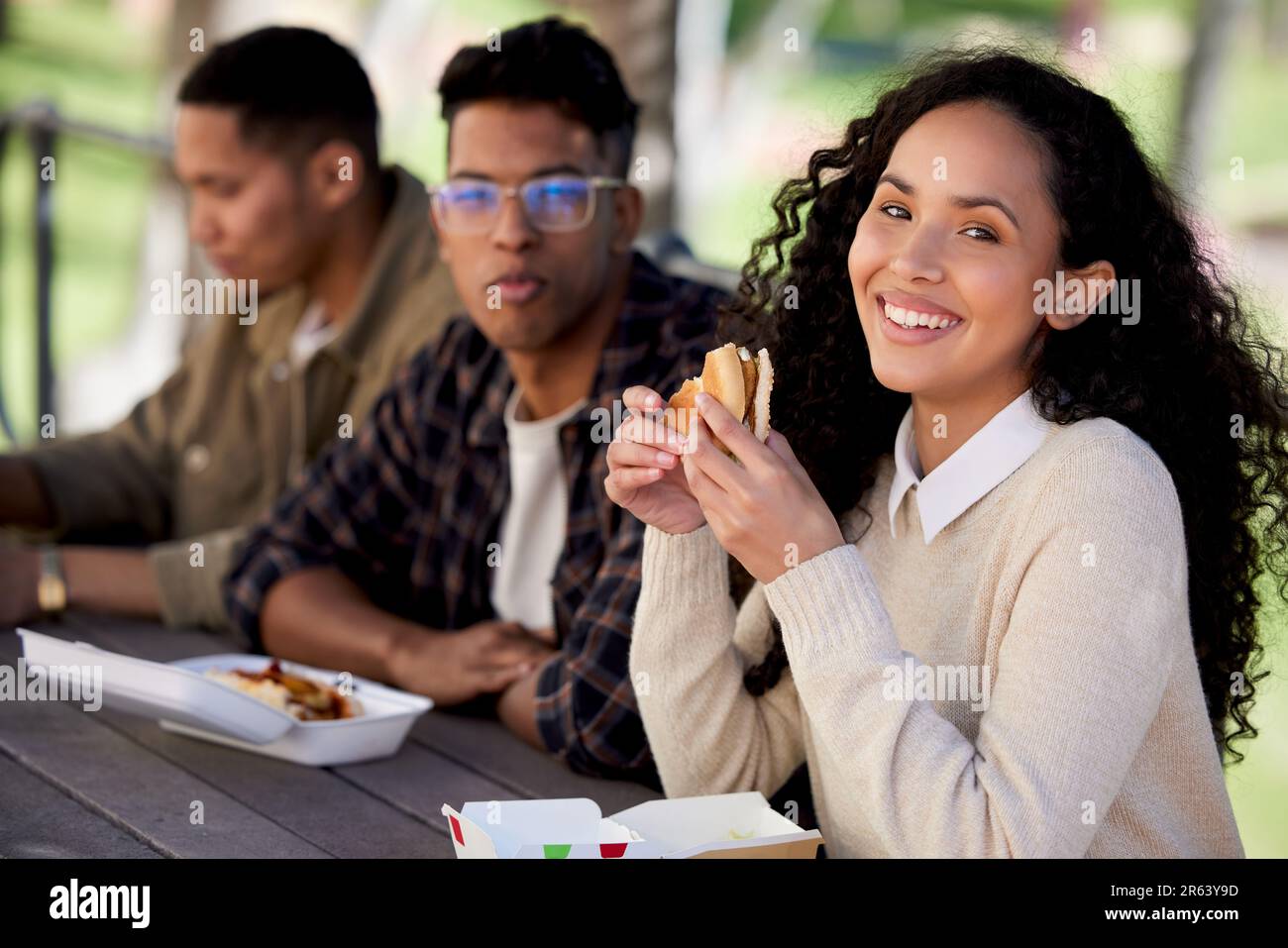 Students, smile and friends eating a burger together in university or ...