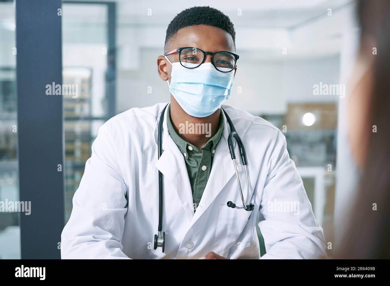 Feel free to ask any questions. a young doctor sitting with his patient ...