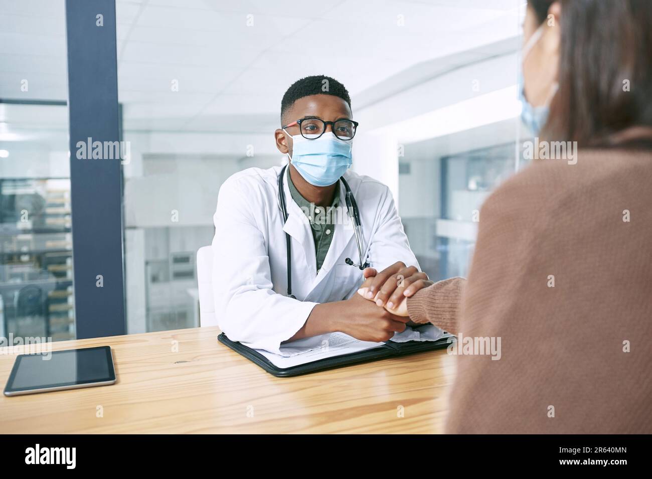 I assure you, you have nothing to worry about. a young doctor sitting ...