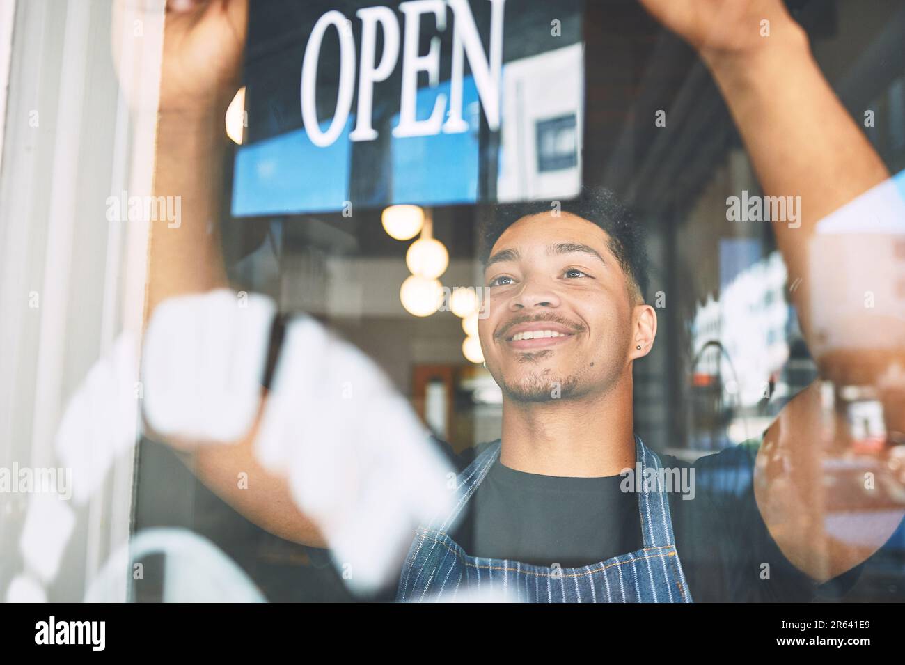 Cant wait to see all you coffee lovers. a young man hanging up an open ...