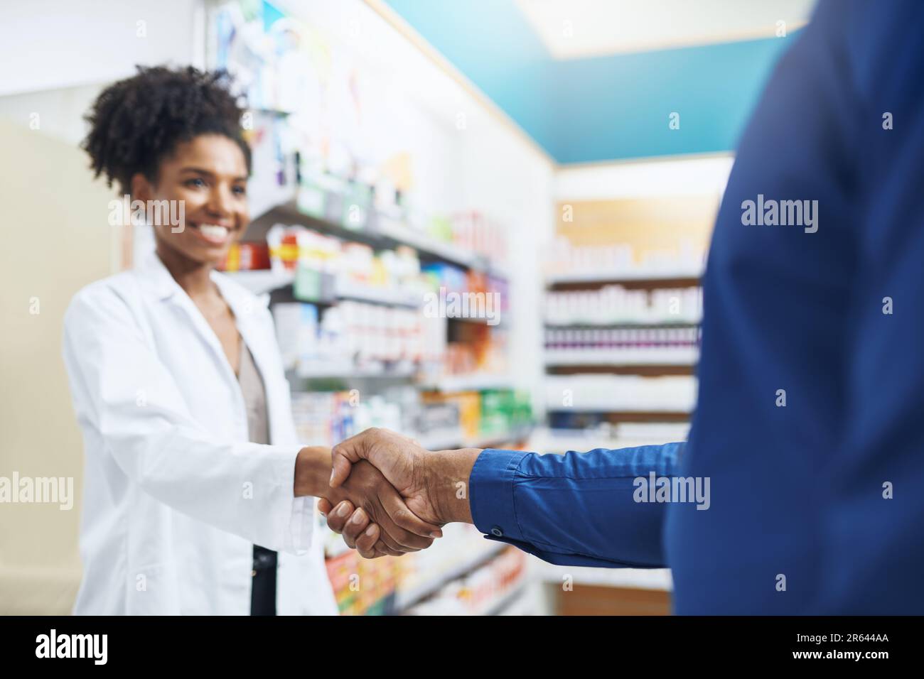 How can I help today. a pharmacist and a customer shaking hands Stock ...