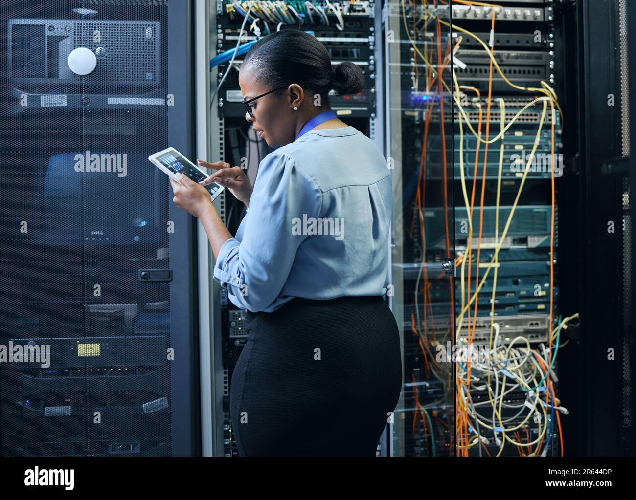 Server room, woman and engineer with tablet for cybersecurity, programming or cable maintenance ...