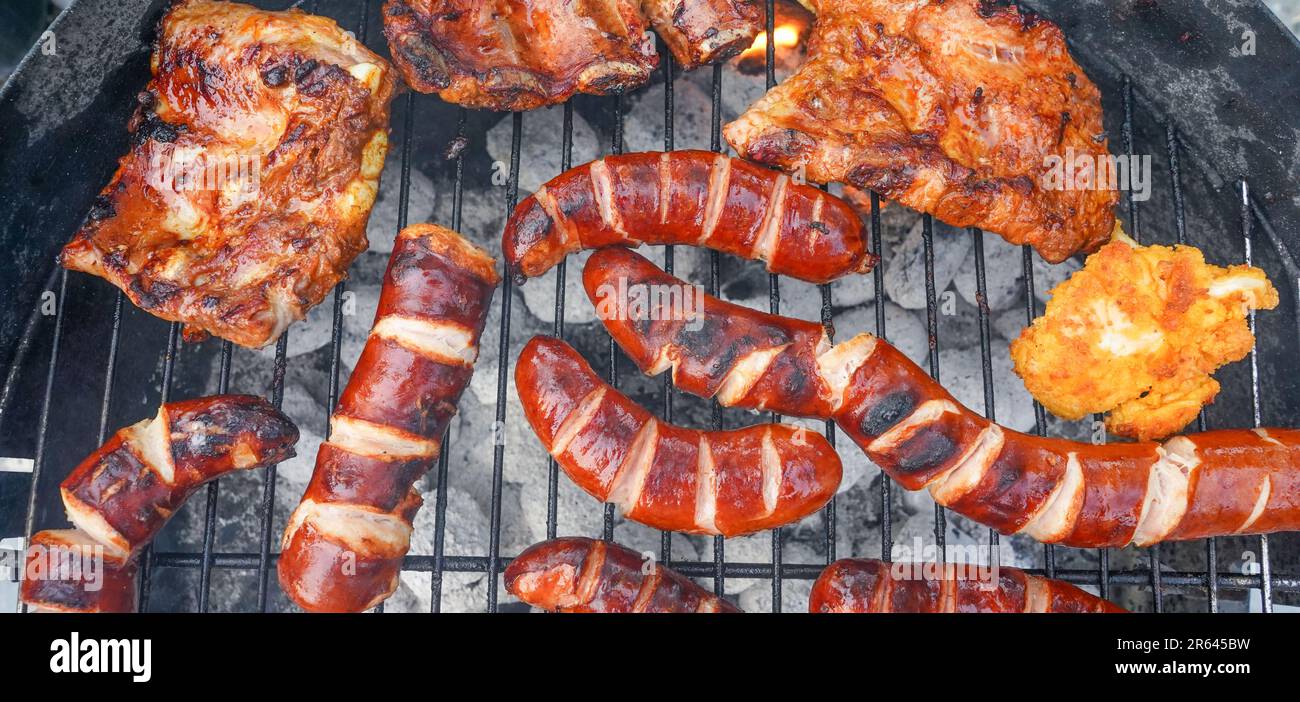 Grilled sausages on barbecue top view. Barbecue in the garden. Grilling ...