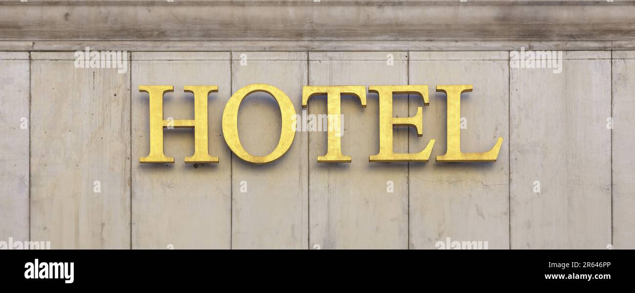 Hotel sign on stone wall building facade, golden letters text front ...