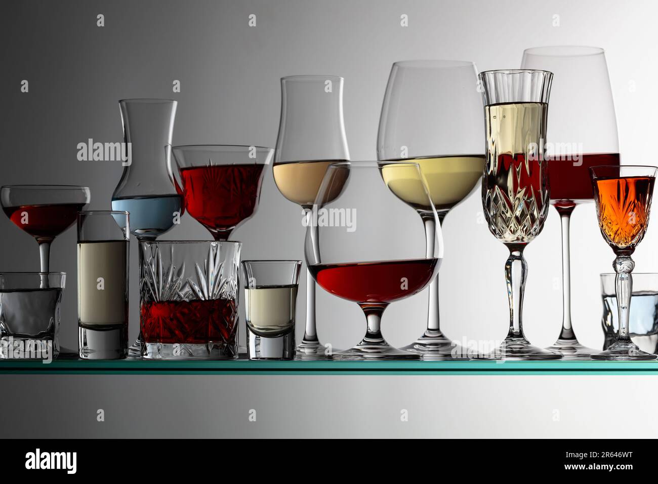 Various alcoholic drinks in a bar on a glass shelf Stock Photo - Alamy