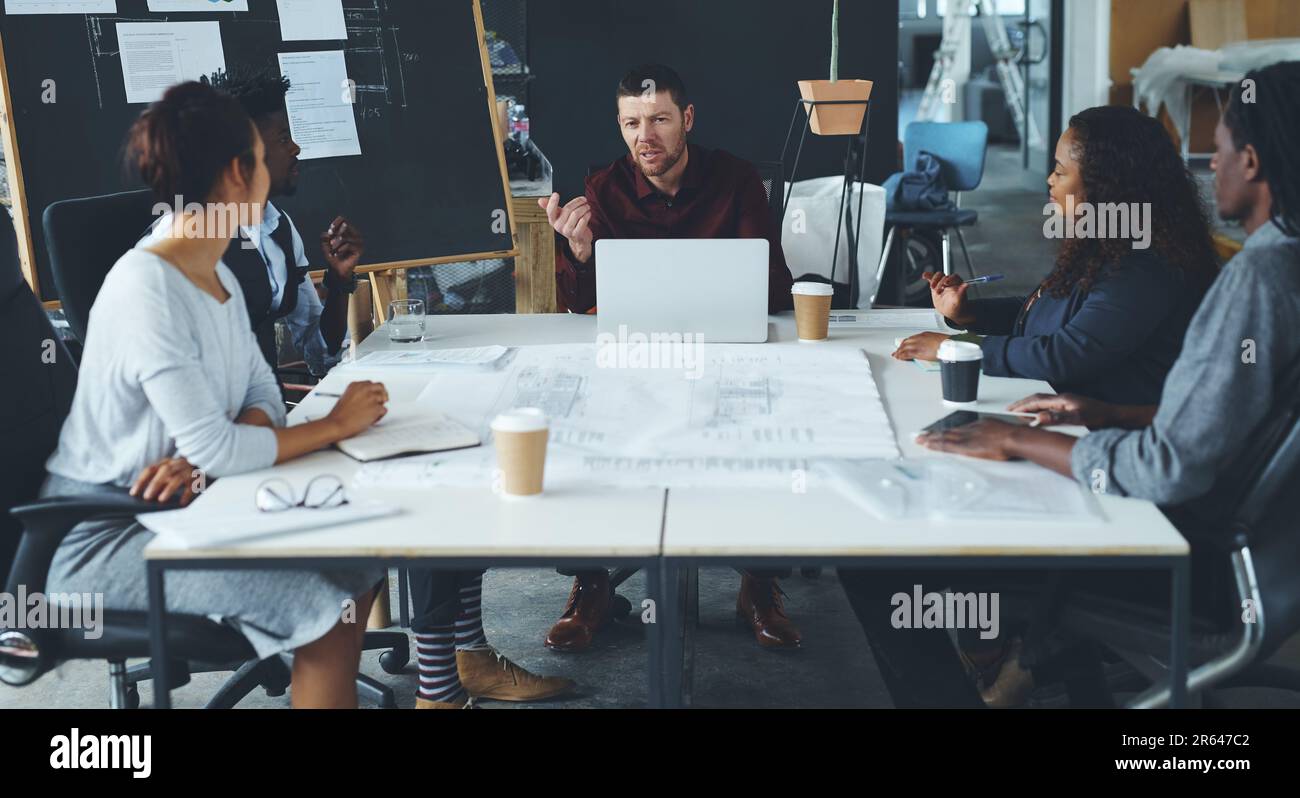 Lets talk about these blueprints. a group of creative businesspeople ...