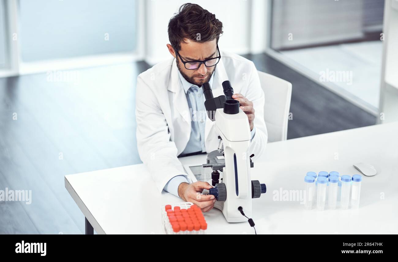 That looks pretty peculiar. a focused young male scientist looking ...