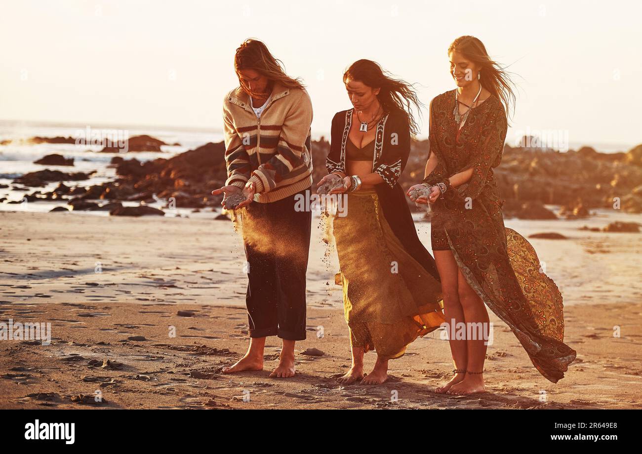 Getting back to mother earth. three gypsies holding sand in their hands ...