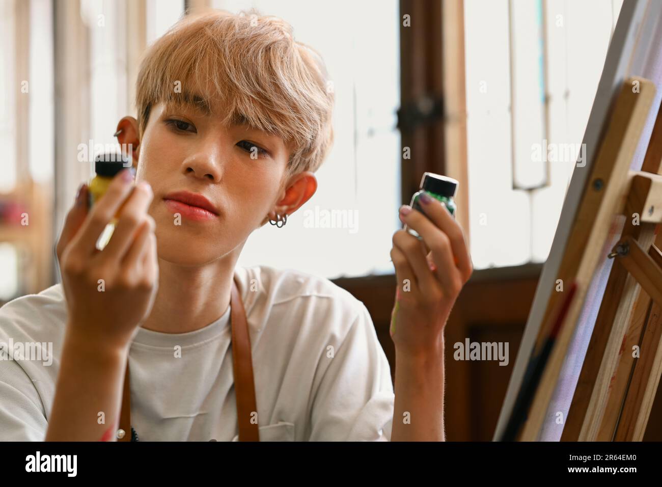 Photo of young gay queer man choosing color for creative artwork. Art ...
