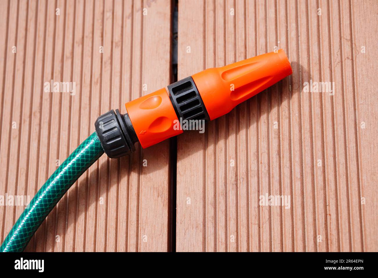 A white plastic hose connected to the side of a wooden deck Stock Photo ...