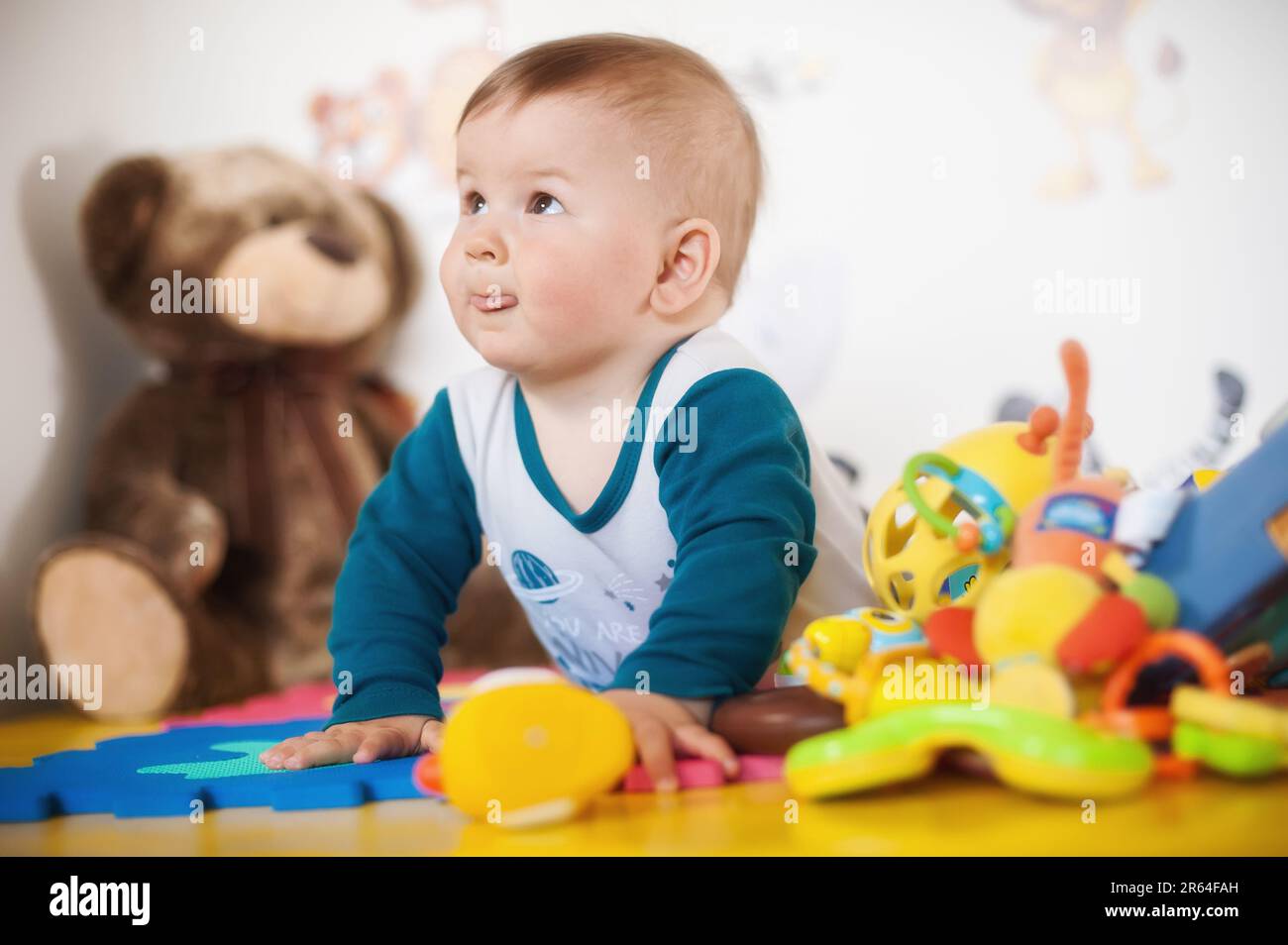 Cute baby boy crawls and explore things around, surrounded with ...