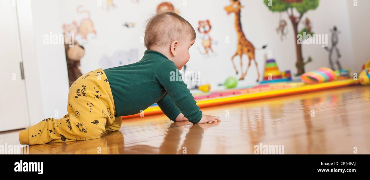Cute baby boy crawls on the home floor, explore the world and learn to ...