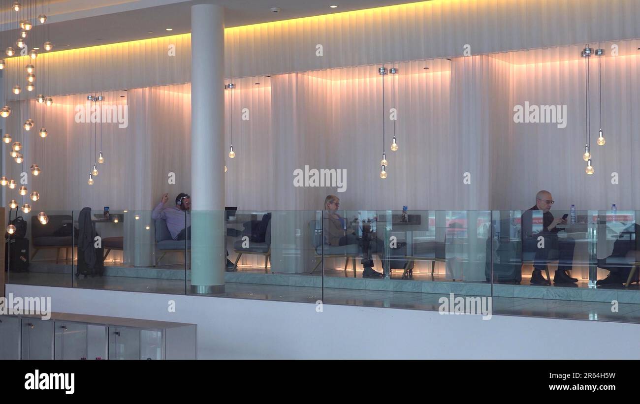 Passengers sit at the 'Blue" restaurant as they wait for their flight ...